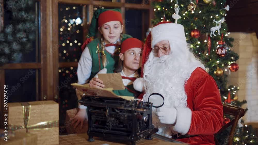 Santa with two elves on Christmas decorated background. Old Santa Claus ...