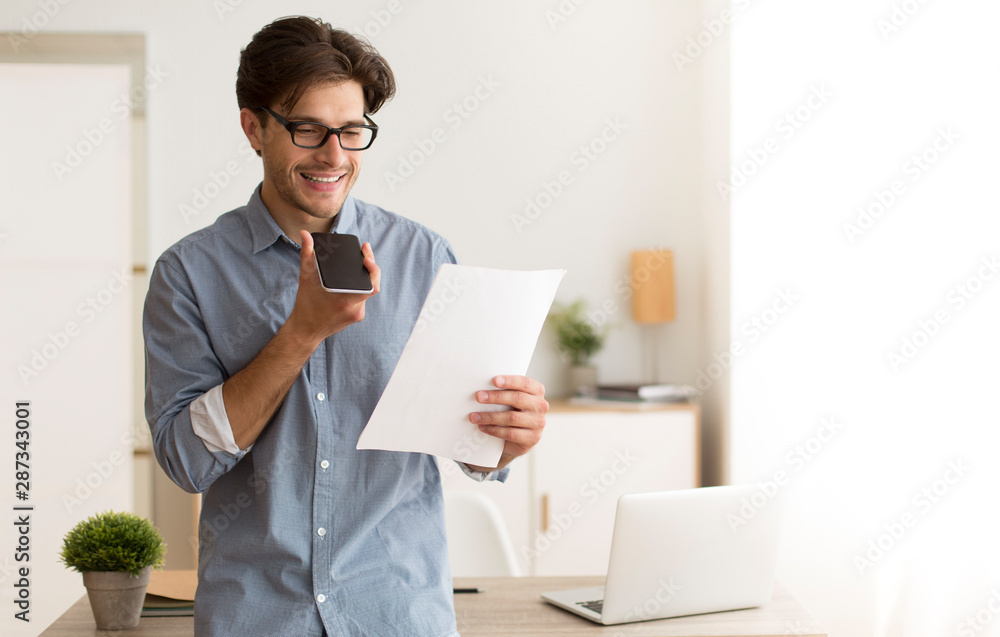 Happy man having phone conversation with bank manager at workplace ...
