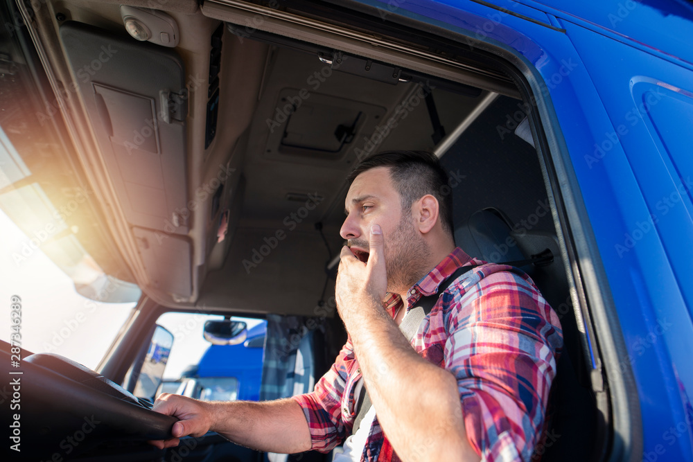 Foto de Truck driver yawning while driving. Trucker feeling sleepy and ...