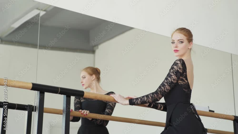 Tracking shot of graceful young ballerina in black lace leatard and ...