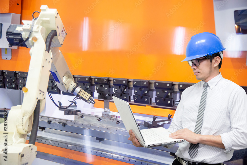 The engineer programming the robotic arms for loading the sheet metal ...