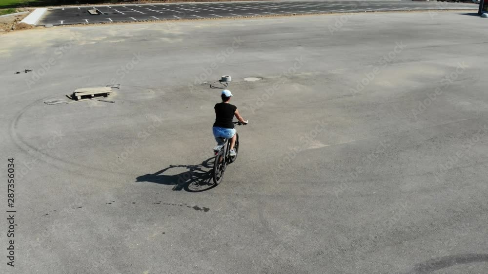 Top view bicycle woman riding a bike on round road in abandoned asphalt ...