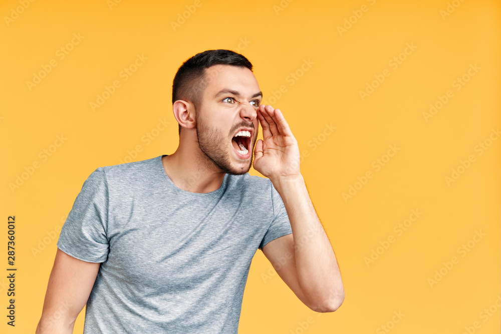 Photo & Art Print Young angry man shouting and screaming loud to side ...