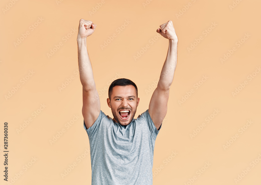 Happy man celebrating his success with winner gesture and hands up ...