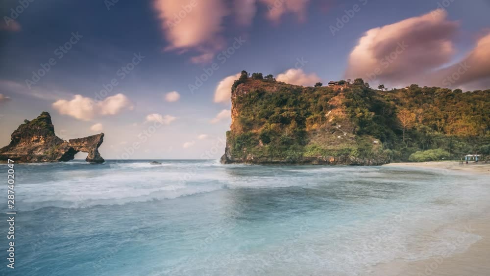 Atuh Beach pictorial rocky cliffs at calm ocean under blue sky with ...