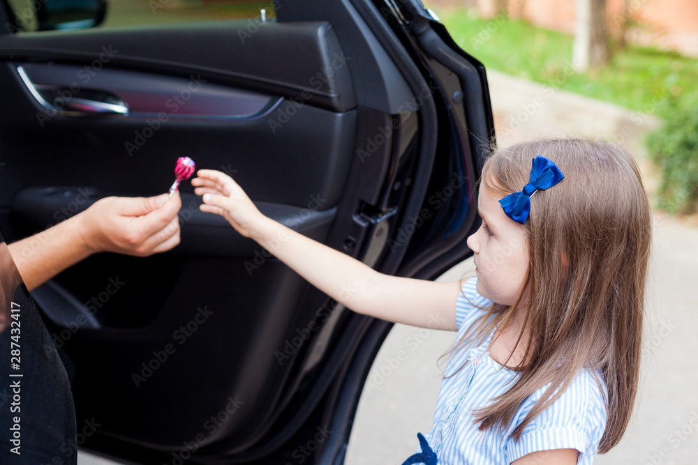 Stranger in the car offers candy to the child. Kids in danger. Children ...
