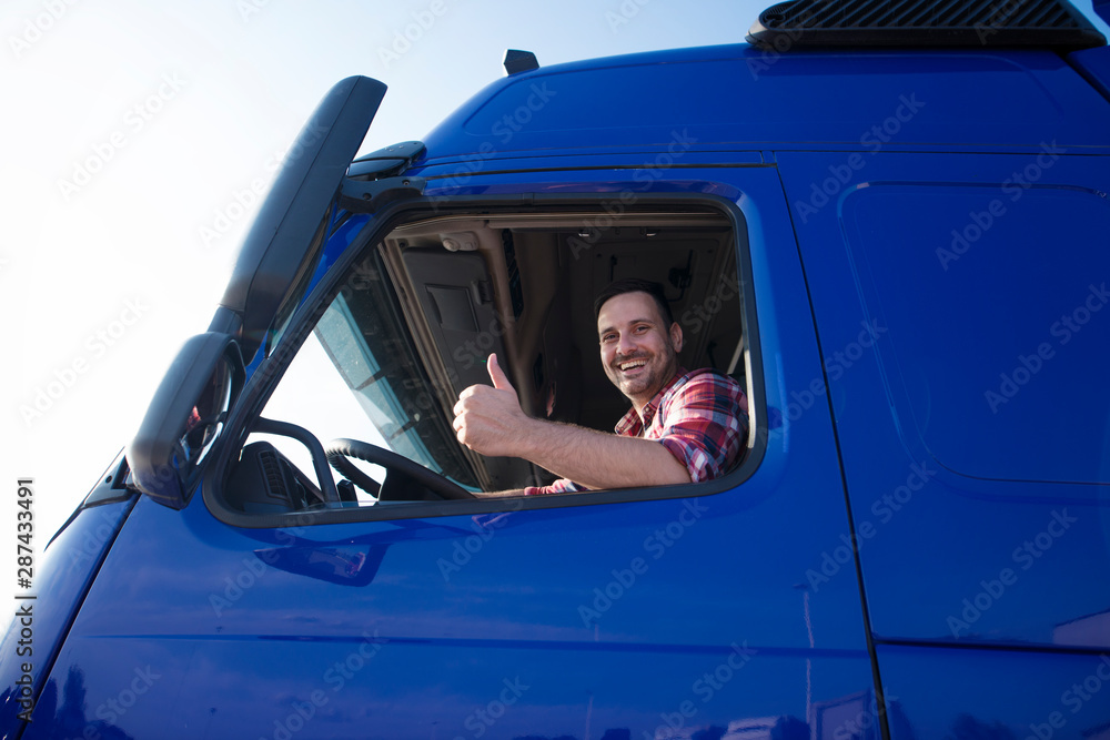 Truck driver showing thumbs up through cabin window. Positive smiling ...