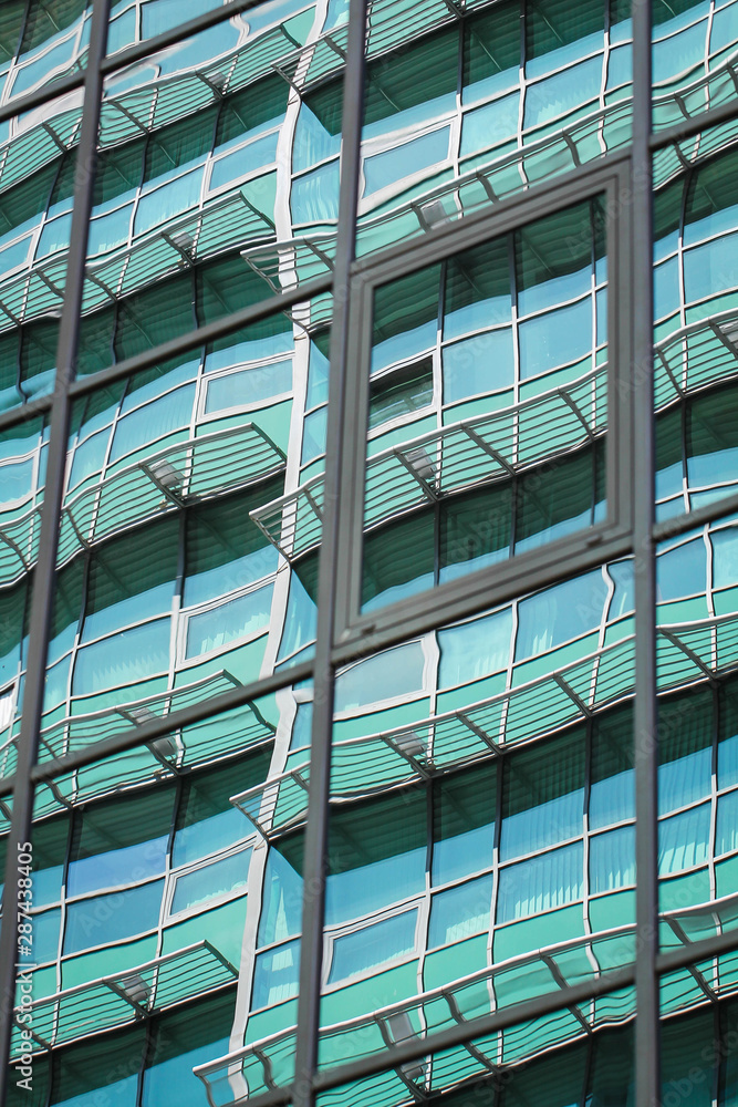 Reflection of windows of a skyscraper. Green windows steel frames ...
