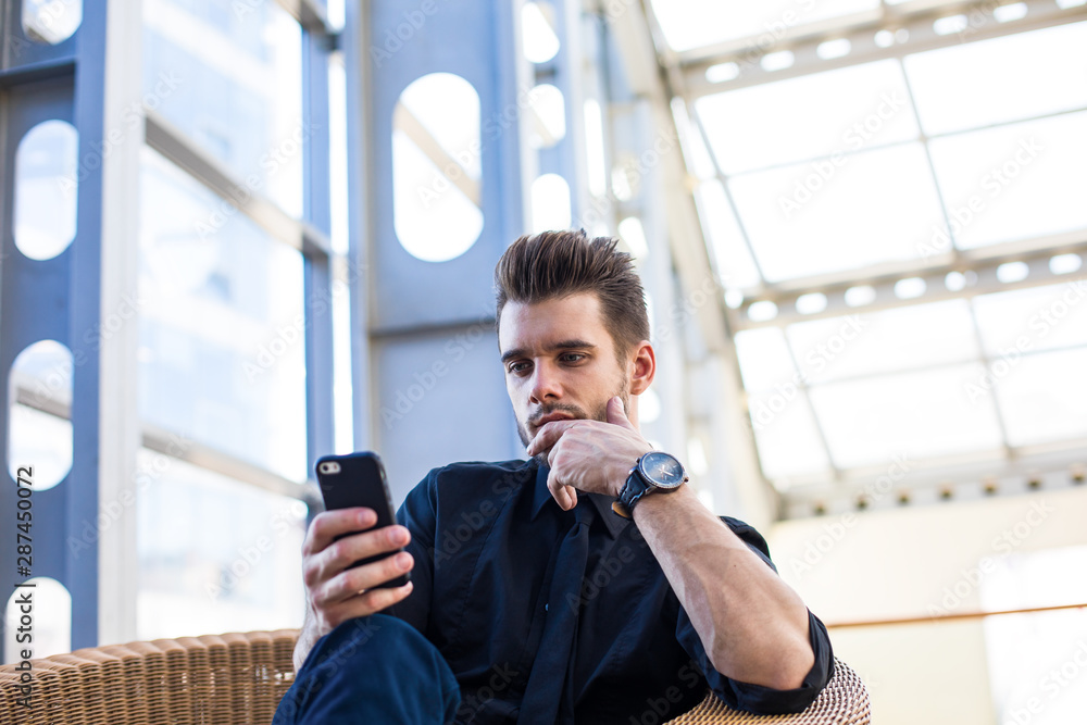 Thoughtful man leadership installing apps on mobile phone,sitting in ...
