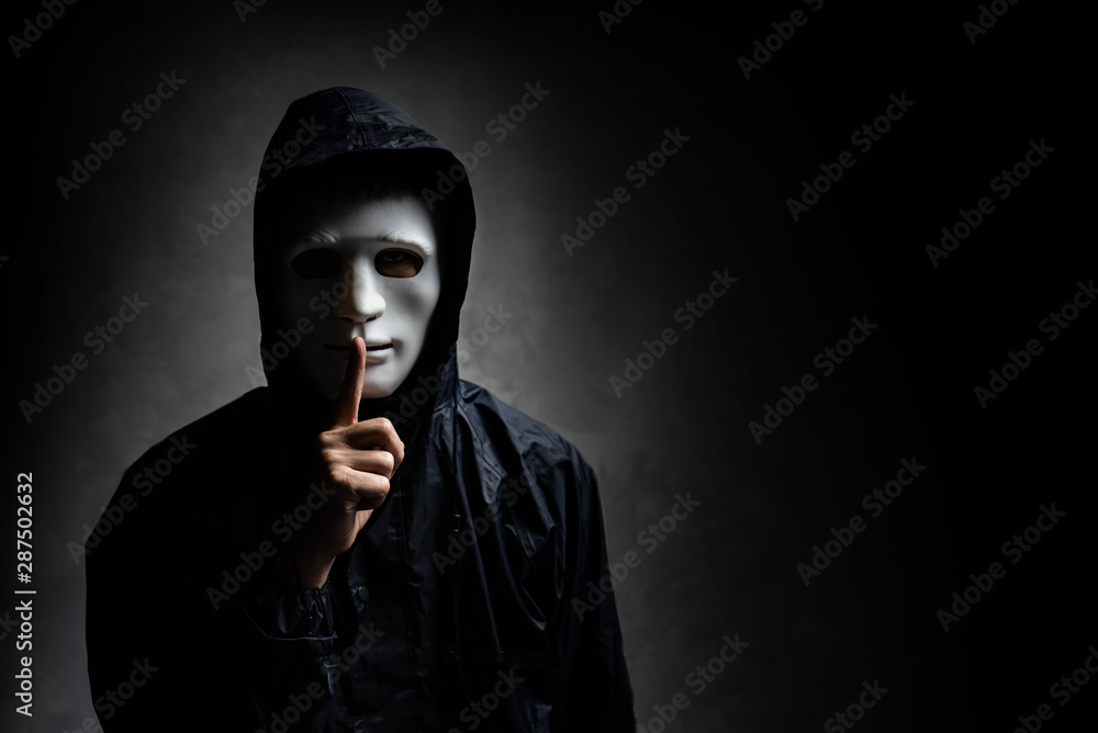 Male hacker hidden face with the mask in the dark. Technology, cyber ...