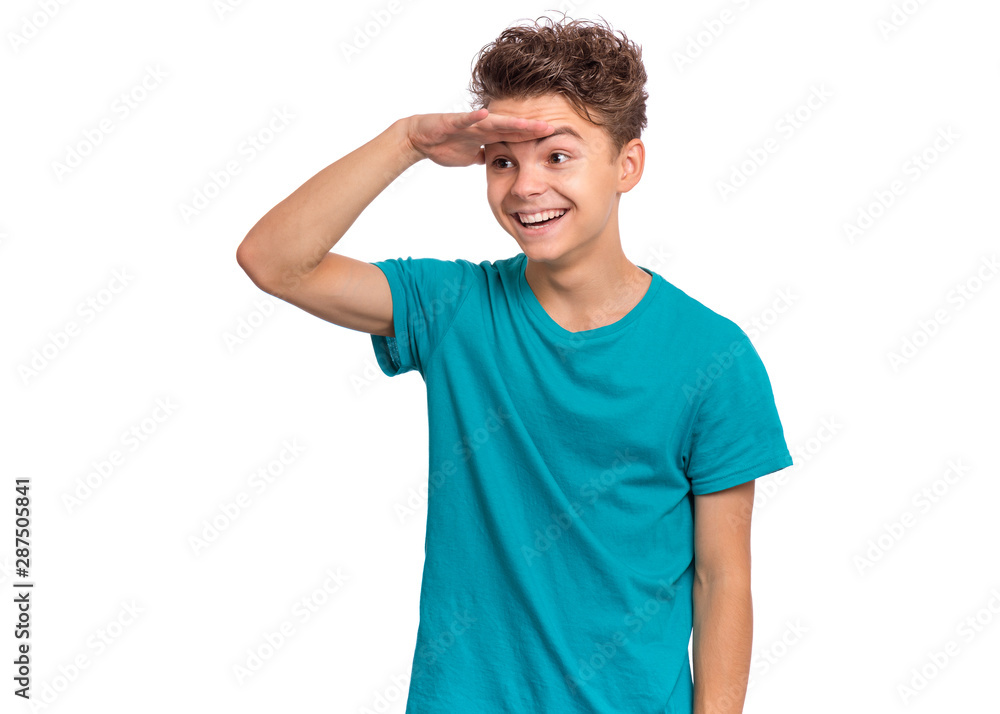 Portrait of very happy teen boy, smiling and looking far away with hand ...