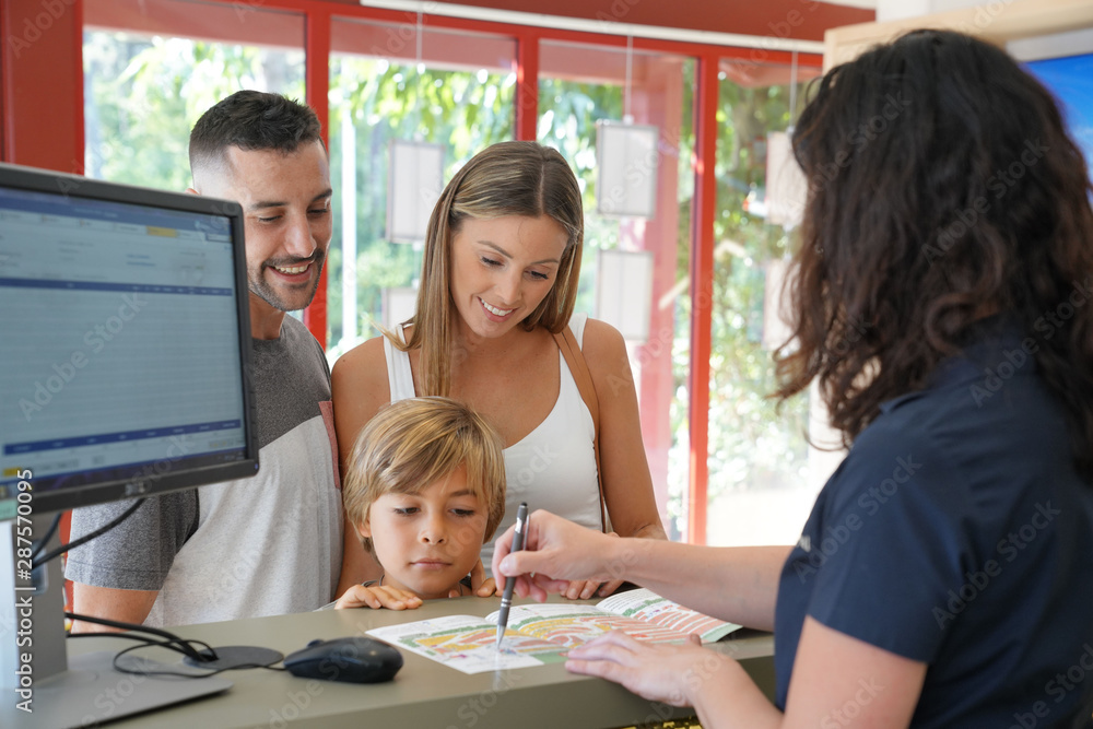 Family checking-in at hotel reception desk Stock Photo | Adobe Stock