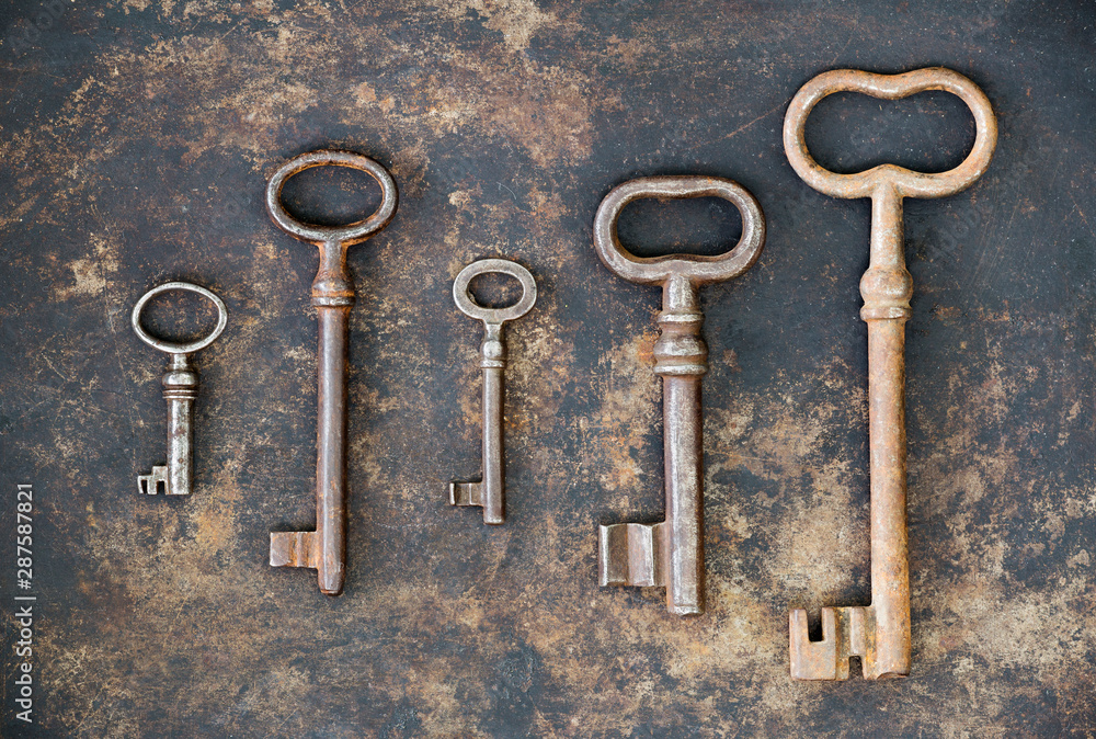 Escape room concept, group of antique keys on rusty metal background ...