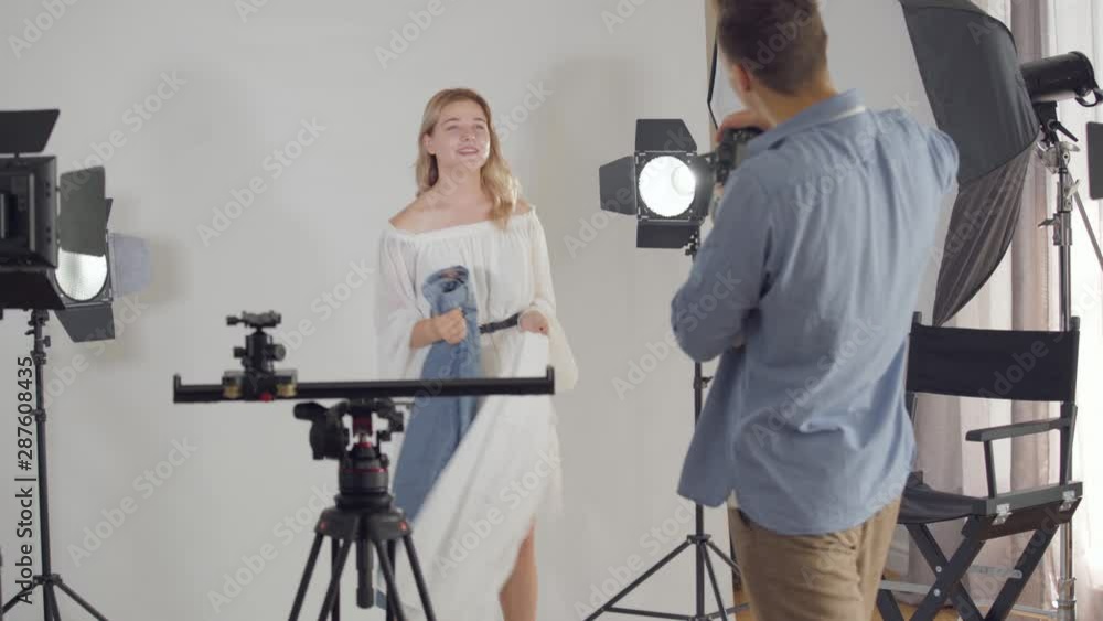 Backstage of the photo shoot. Photographer taking photos of cute girl ...