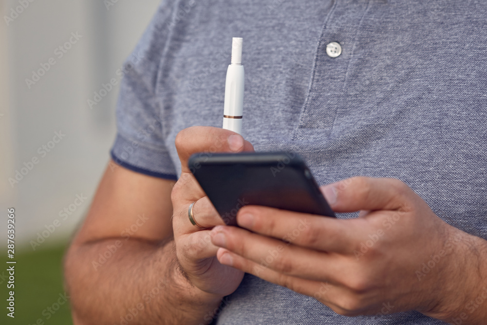 Electronic cigarette in male hands. Cigarette technology. Tobacco IQOS ...