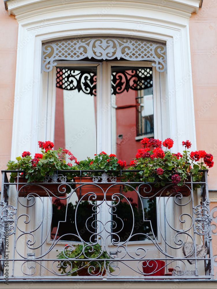 Beautiful balcony with white window frames and red flowers in the ...