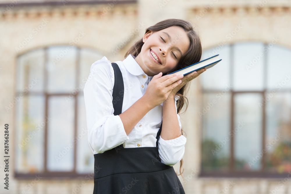 Need for sleep. School education concept. Cute smiling sleepy child hold book. Little girl ...