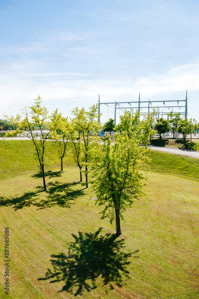 Young green trees with hydroelectric power plant at Centrale ...