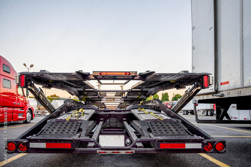 Big rig semi truck with two levels car hauler semi trailer standing in ...