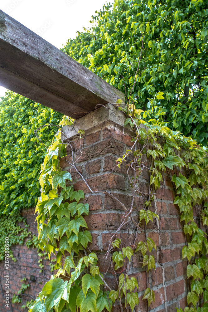 A heavy timber weathered wood beam extends across a pedestrian walkway ...