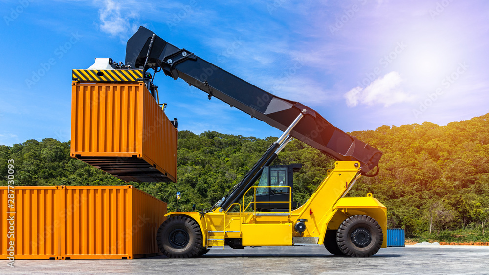 Reach stacker yellow forklift truck handling shipping container in ...