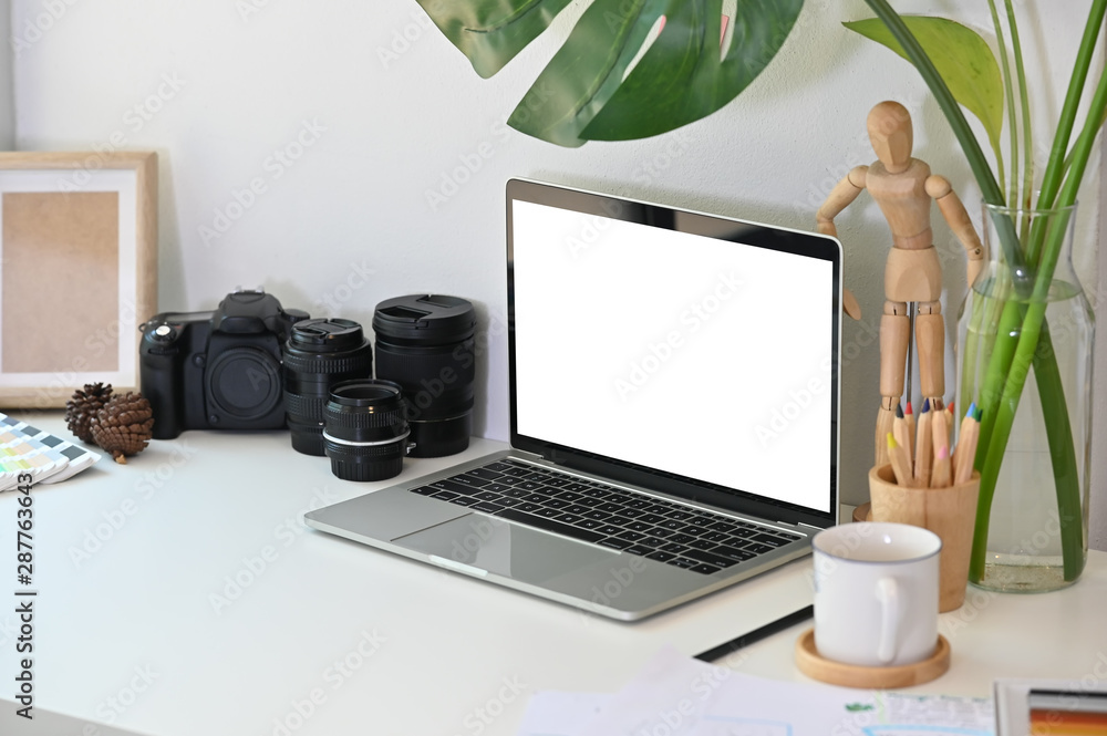 Mockup laptop computer, camera and lens on creative workspace with ...