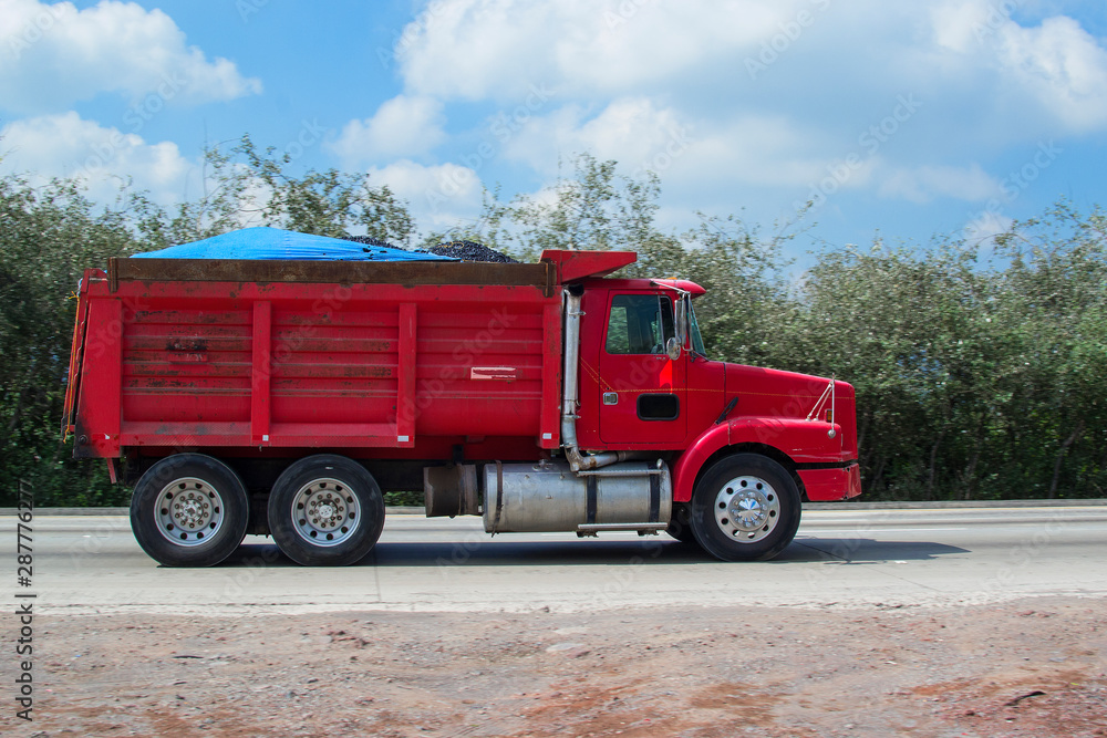 camión de volteo circulando por la autopista ภาพถ่ายสต็อก | Adobe Stock