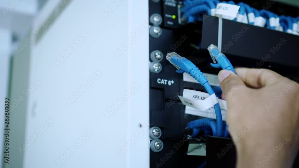 Technician is connecting the internet signal system in the office room ...
