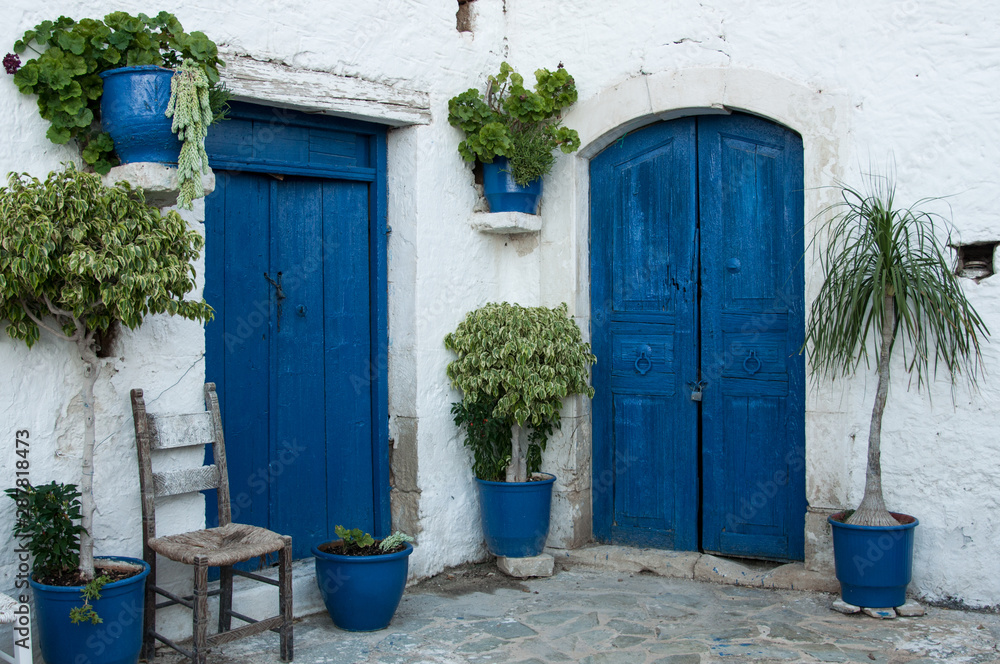 Traditional Mediterranean house facade with wooden doors. White and ...
