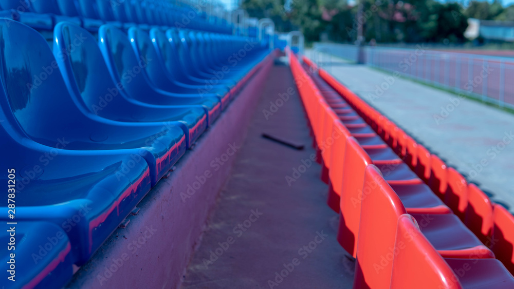 Bleachers in a sports stadium. Red and blue seats in a large street ...