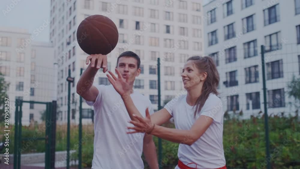 Young people have fun on sport court. Man show off his skill of ball ...