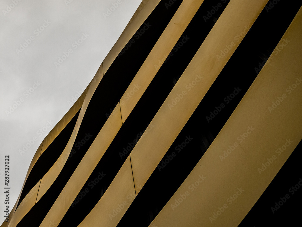Tilted view of parallel golden balconies in modern building facade ...