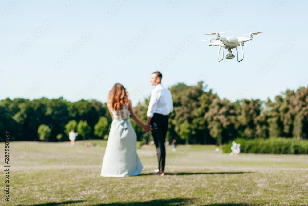 Hovering drone taking pictures of wedding couple in nature Stock Photo ...