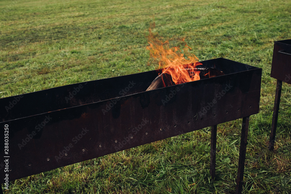 Side view of brazier with flaming fire and firewood. Process of ...