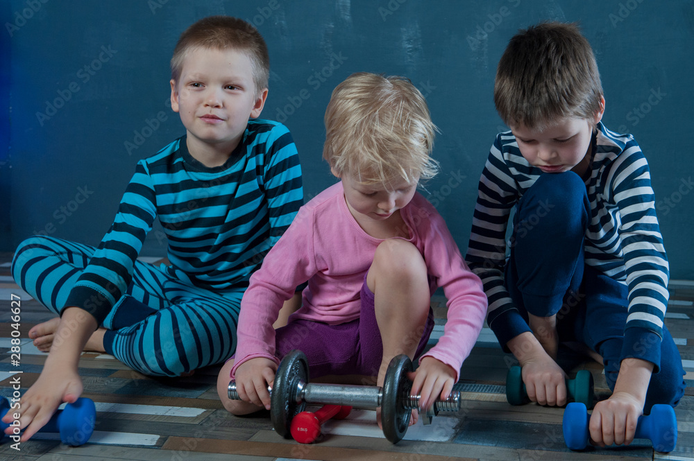 Three children are sitting on floor in room and are going to do ...