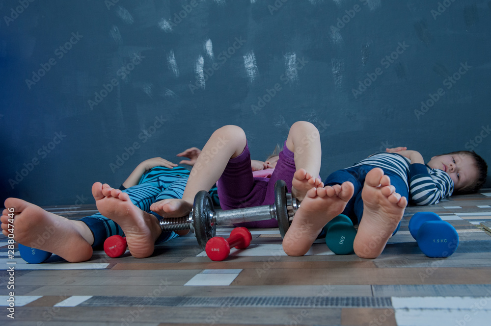 Three children are sitting on floor in room and are going to do ...