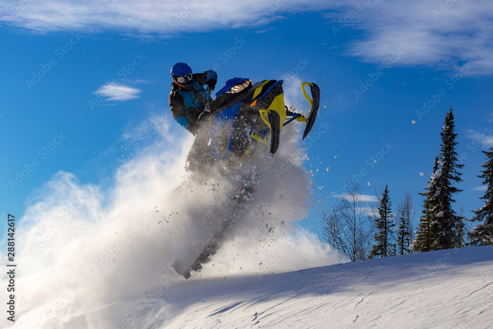 snowmobile jump. bright snowmobile in motion. the guy is flying on a ...