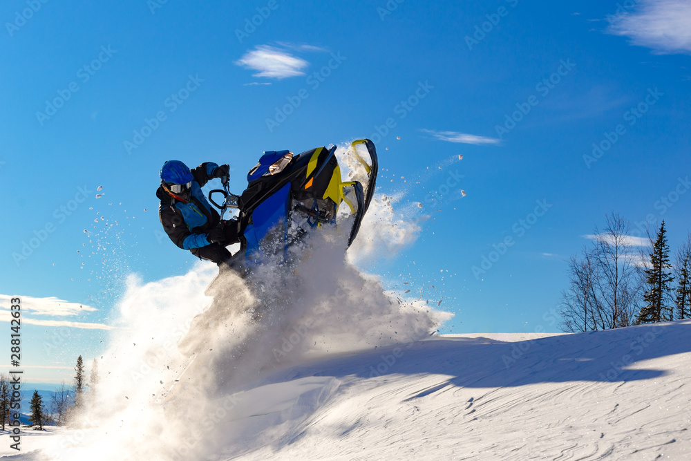 snowmobile jump. bright snowmobile in motion. the guy is flying on a ...