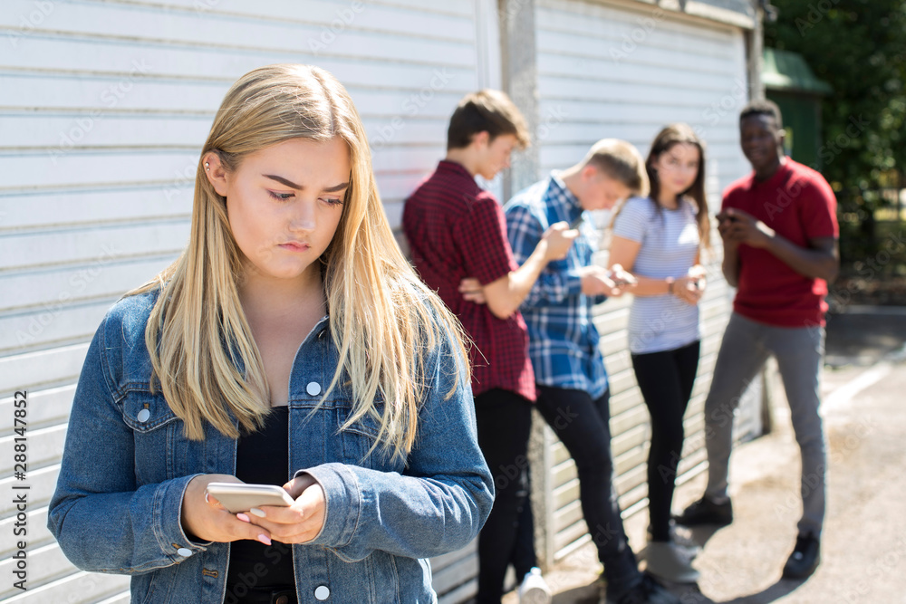 Unhappy Teenage Girl Being Bullied By Text Message Outdoors Stock Photo ...
