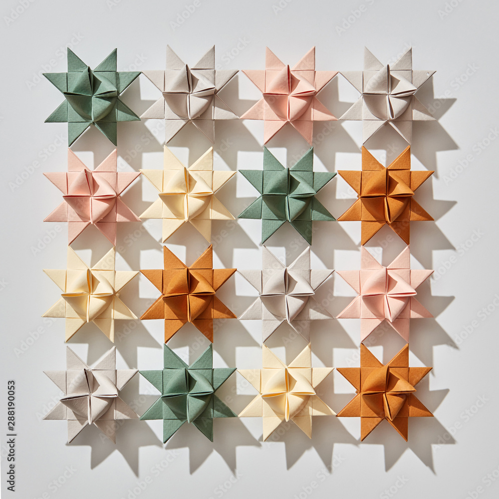 Composition from multi-colored paper stars origami on a gray background ...