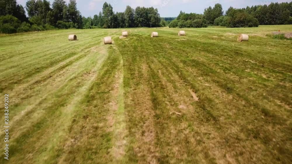 Flying just feet over the top of this hay field and its hay bales. A ...