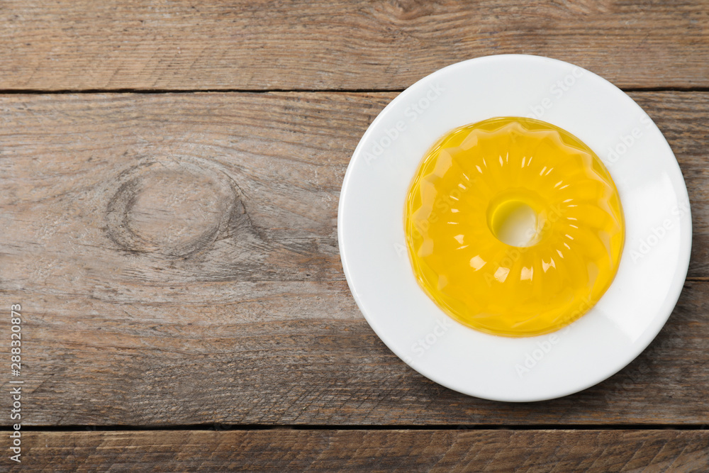 Delicious fresh yellow jelly on wooden table, top view. Space for text ...