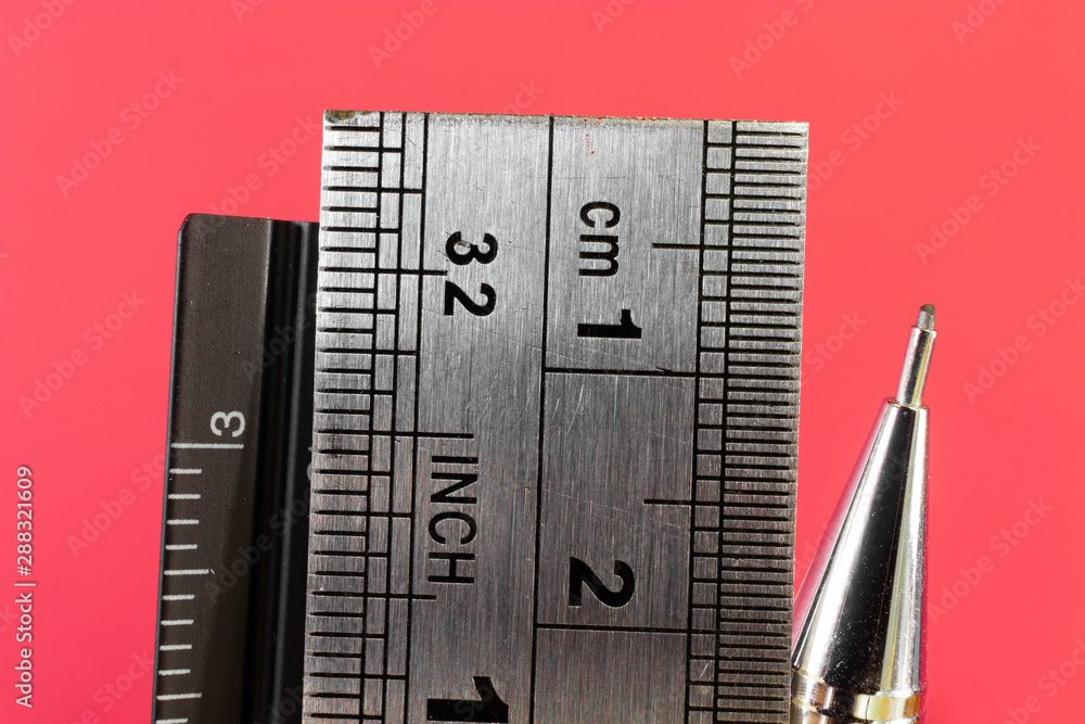 Rulers and mechanical pencil macro image in red background. High ...