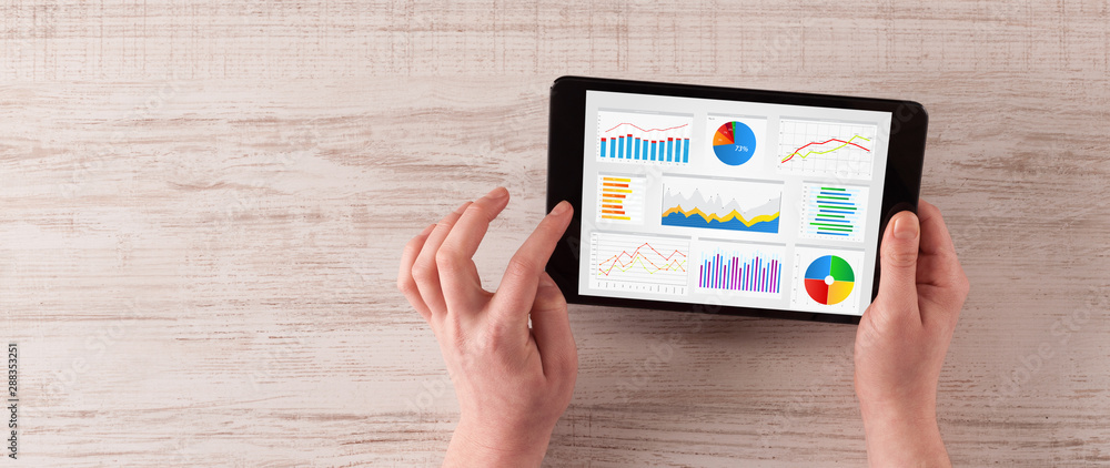 Hand making diagrams and charts on tablet Stock Photo | Adobe Stock