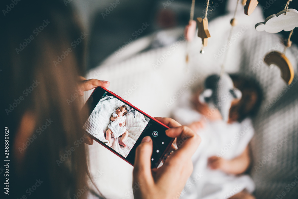 Mother taking a picture of A baby with a mobile phone. Stock Photo ...