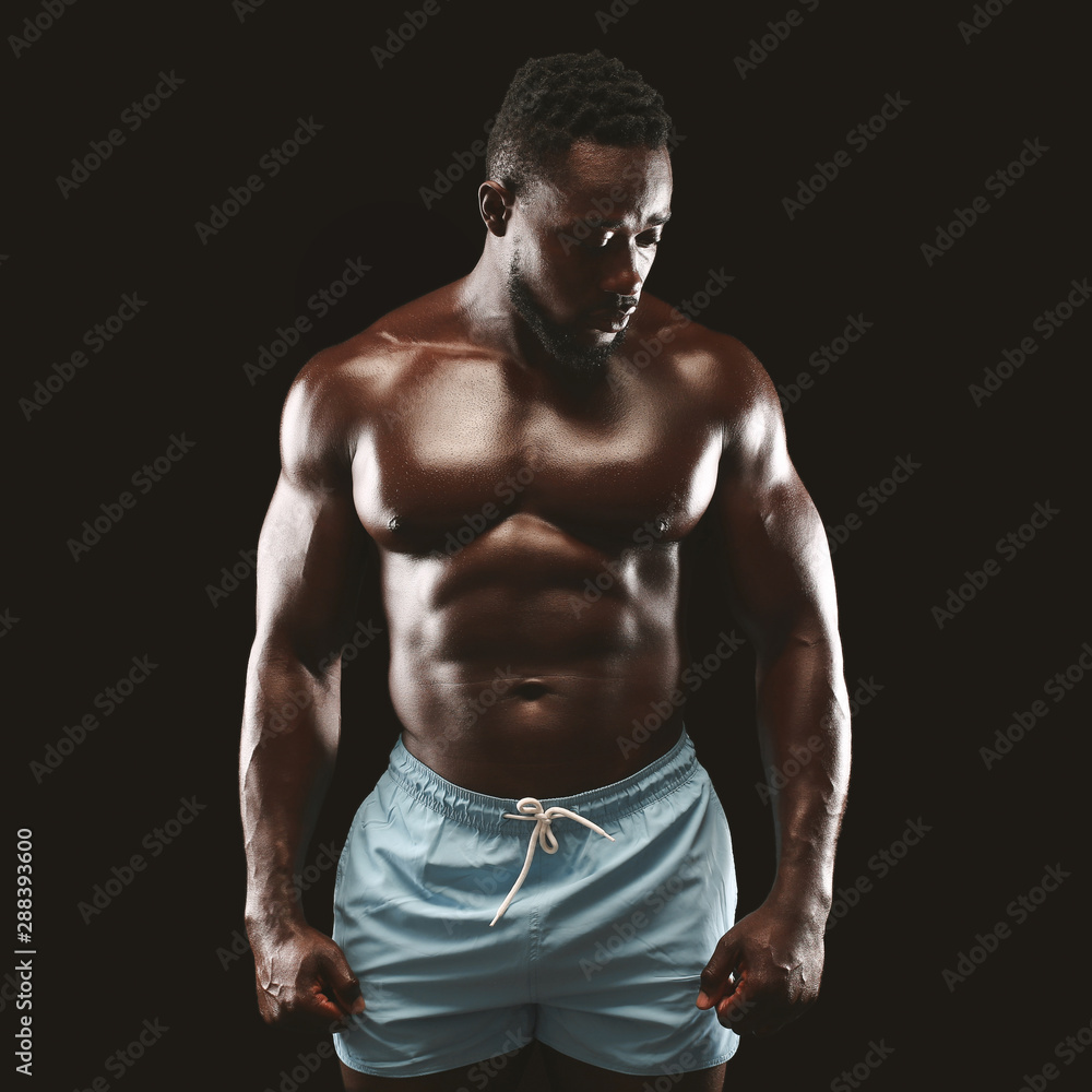 Strong athletic black man posing at studio, demonstrating muscular body ...