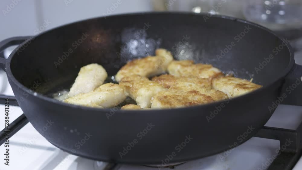 Making pan fried cod fish fillet in cast iron frying pan with cooking ...