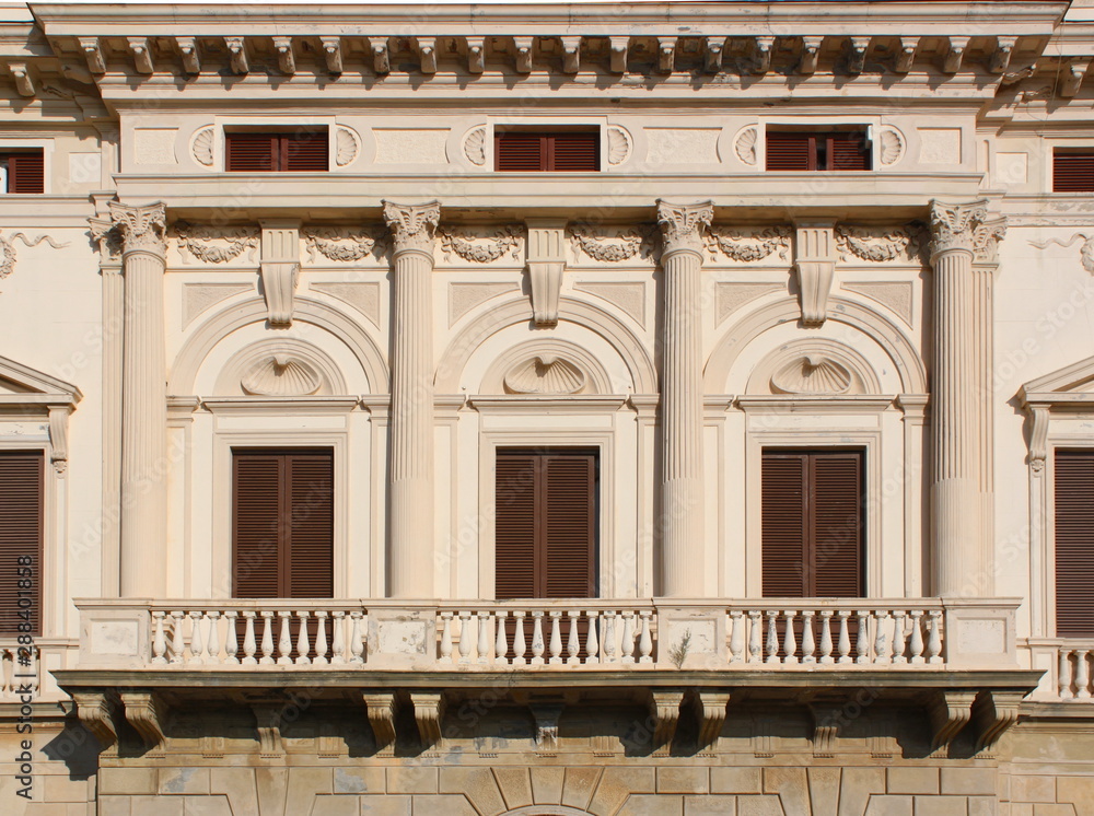 Neoclassical palace facade detail with closed windows, balcony and ...