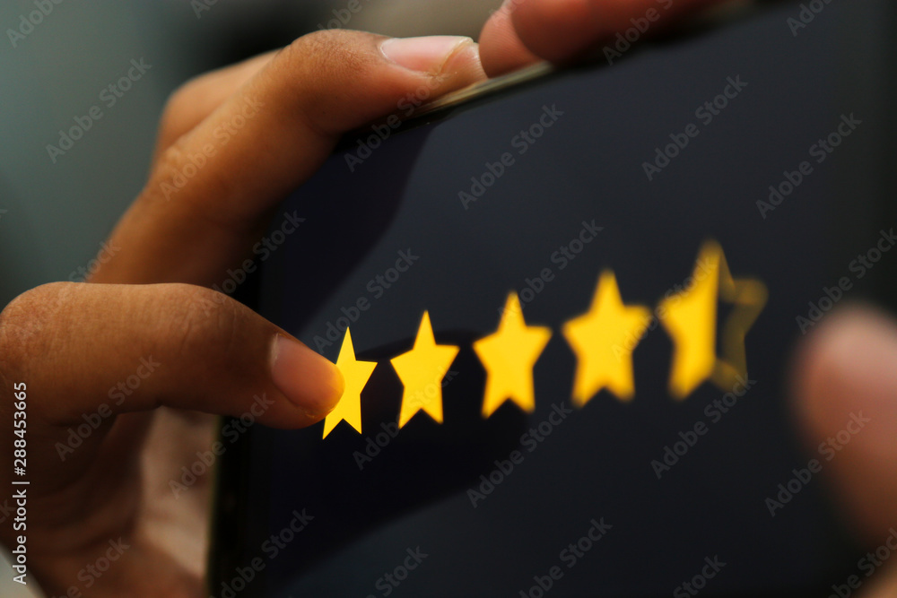 attractive hands giving four point five star rating on a smart phone ...