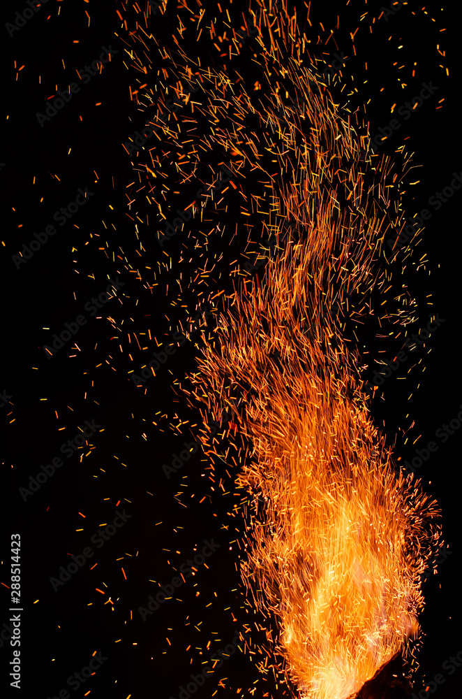 Flame of fire with flying burning red sparks on a black background ...